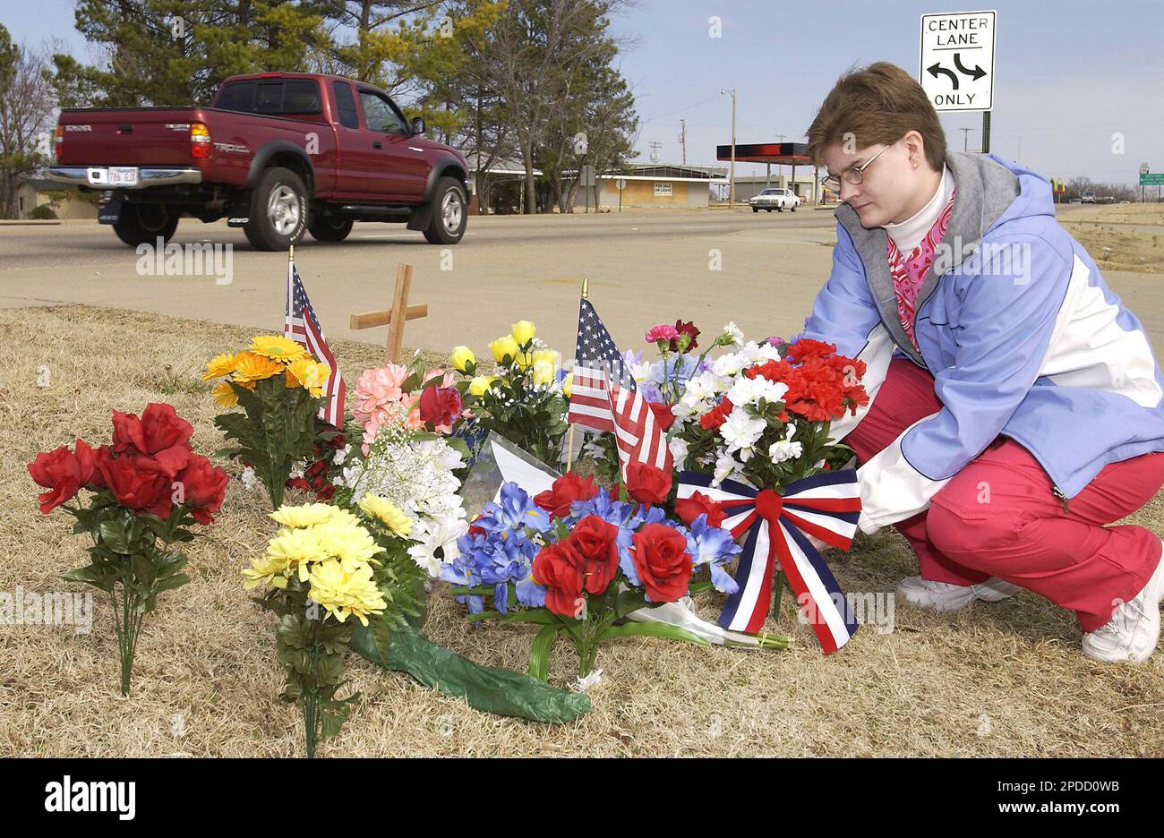 Amber Bellegarde, of Summit, Ark., places flowers at a makeshift ...