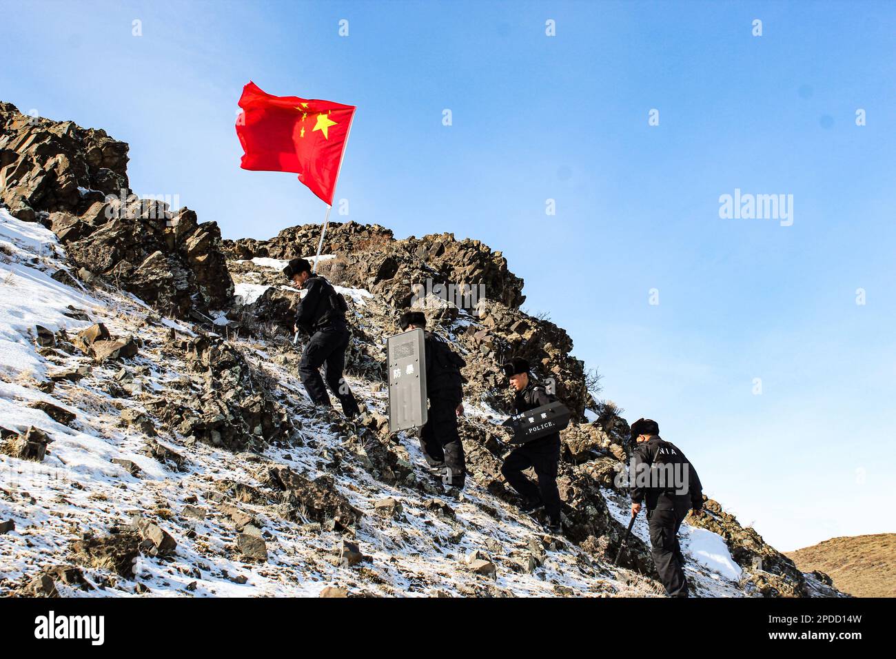 ALTAY, CHINA - MARCH 14, 2023 - Police officers hold national flags as ...