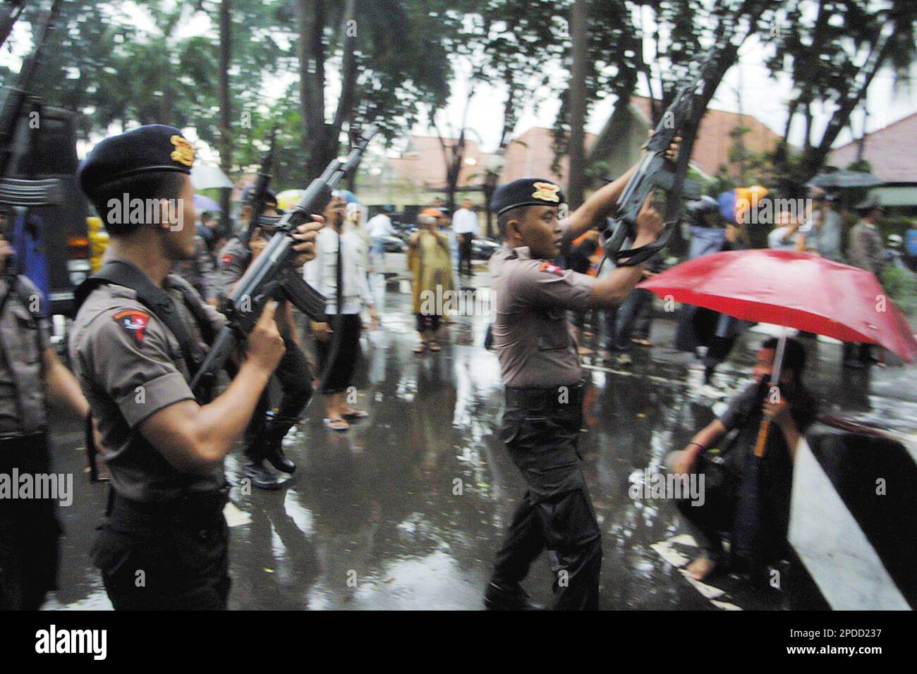 Indonesian police officers fire warning shots to disperse a crowd of ...