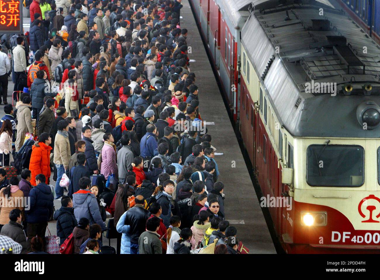 Passengers wait to board a train at the railway station in Nanjing in ...