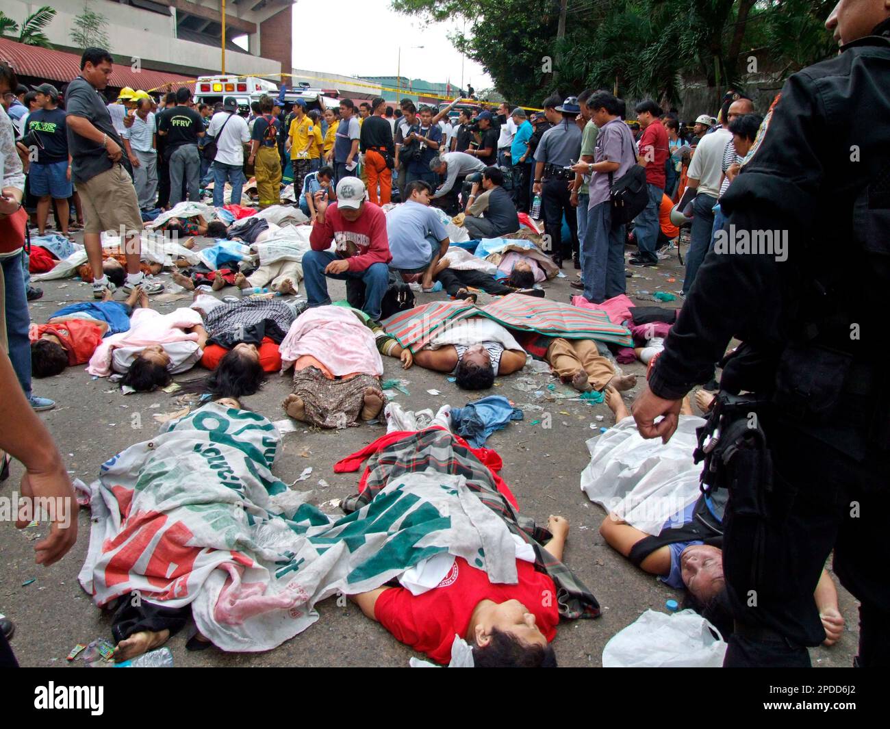 Bodies of victims of an early morning stampede are laid on the road ...
