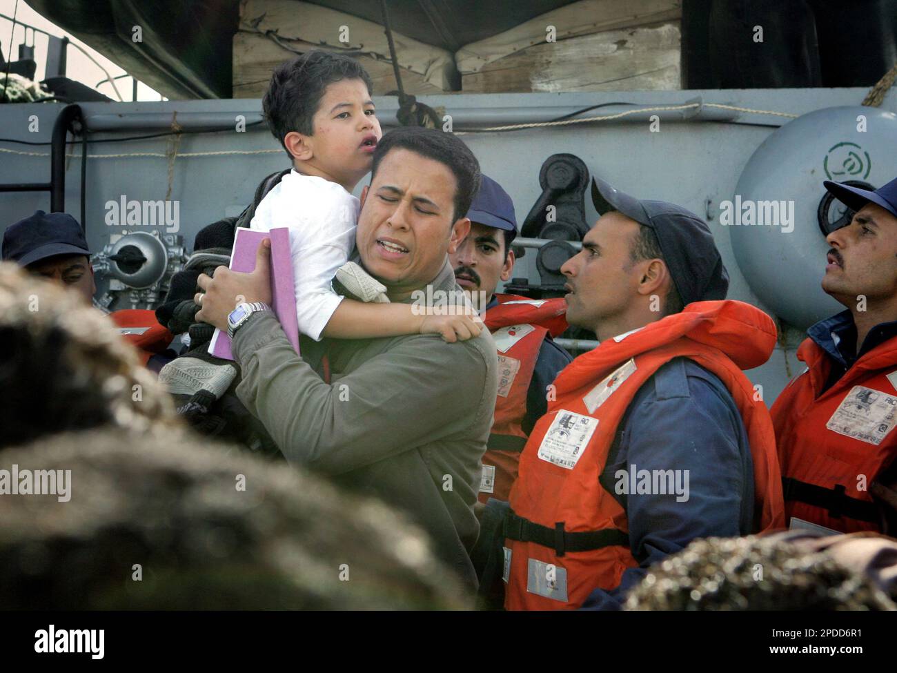 A man and child who were survivors of the ferry sinking disembark an ...