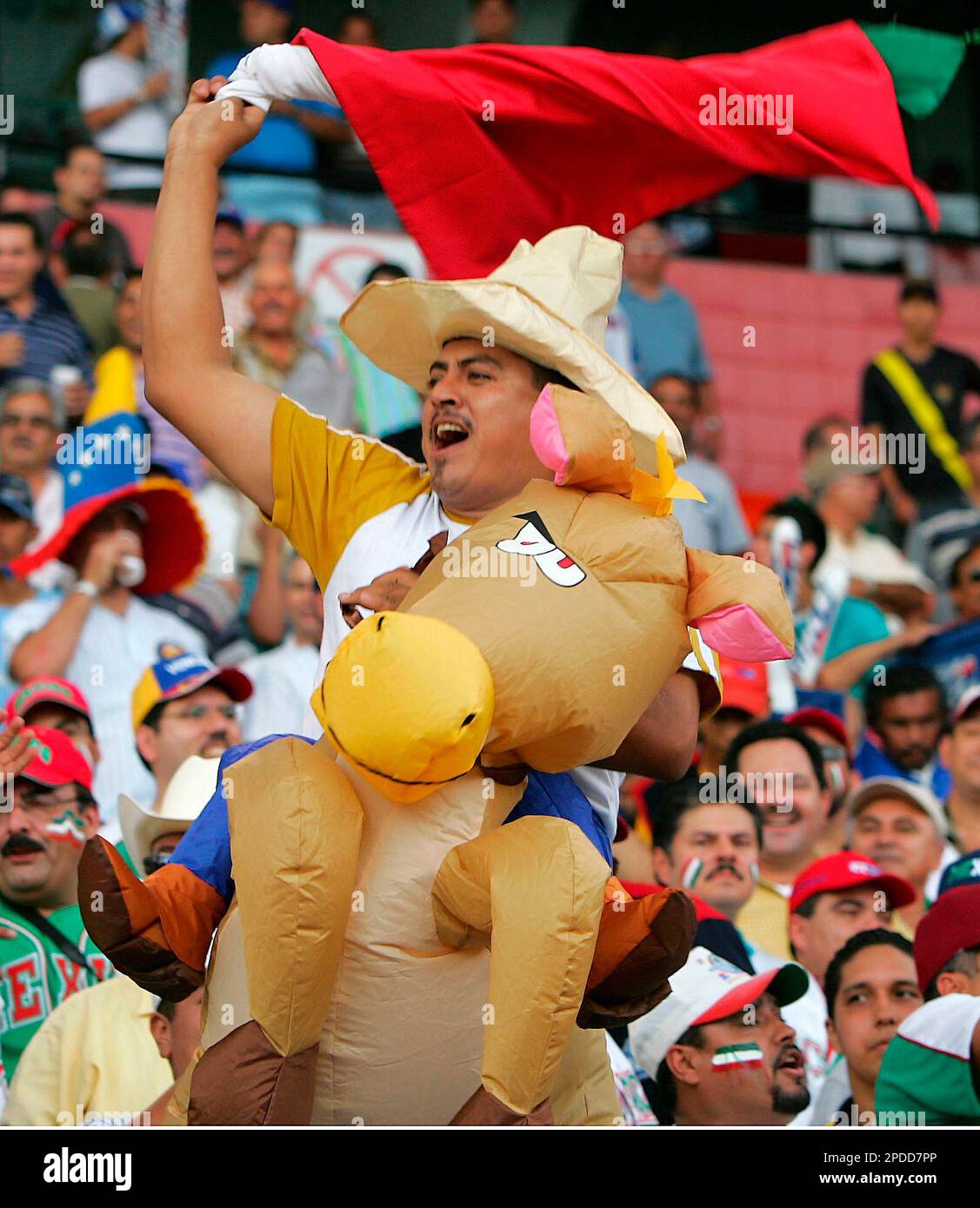 A Mexico baseball dressed as a cowboy cheers for his team during a ...