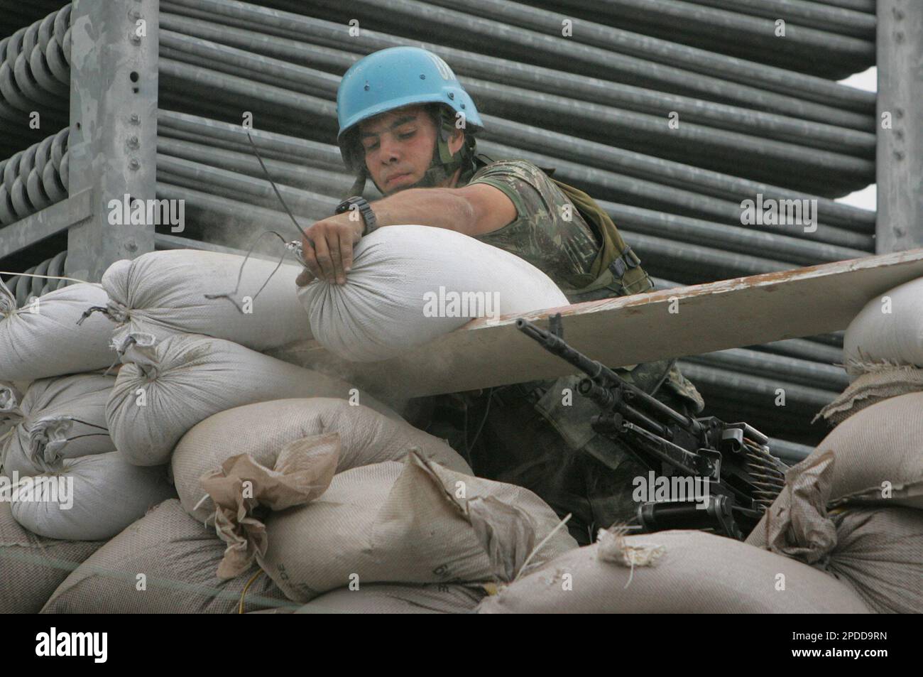 A Brazilian United Nations soldier sandbags a roof-top machine-gun ...