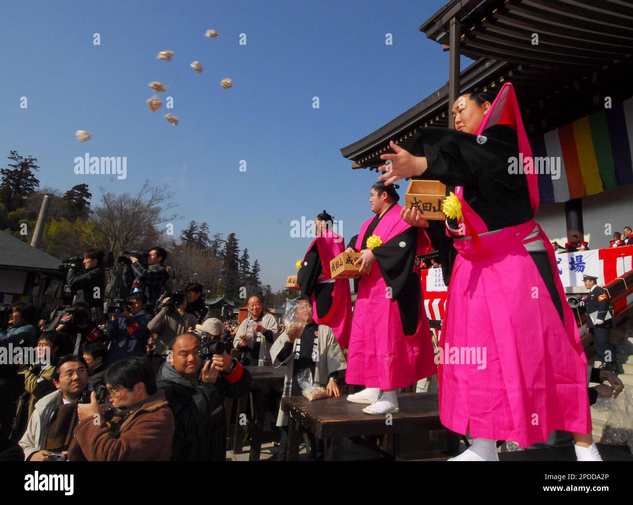 Mongolian-born sumo grand champion Asashoryu, right, tosses packs of ...
