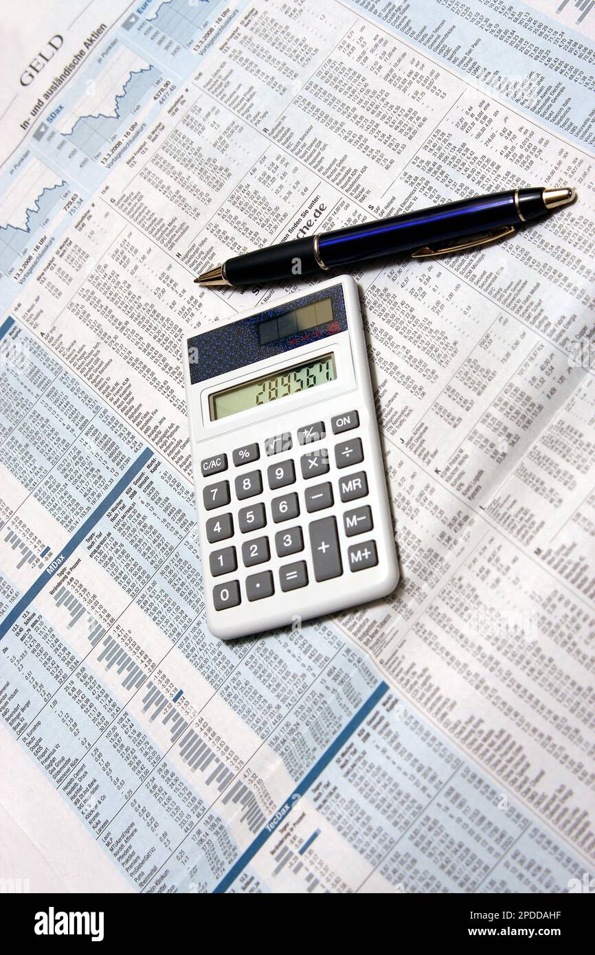 page with stock-market infos in a newspaper, calculator and ballpen ...