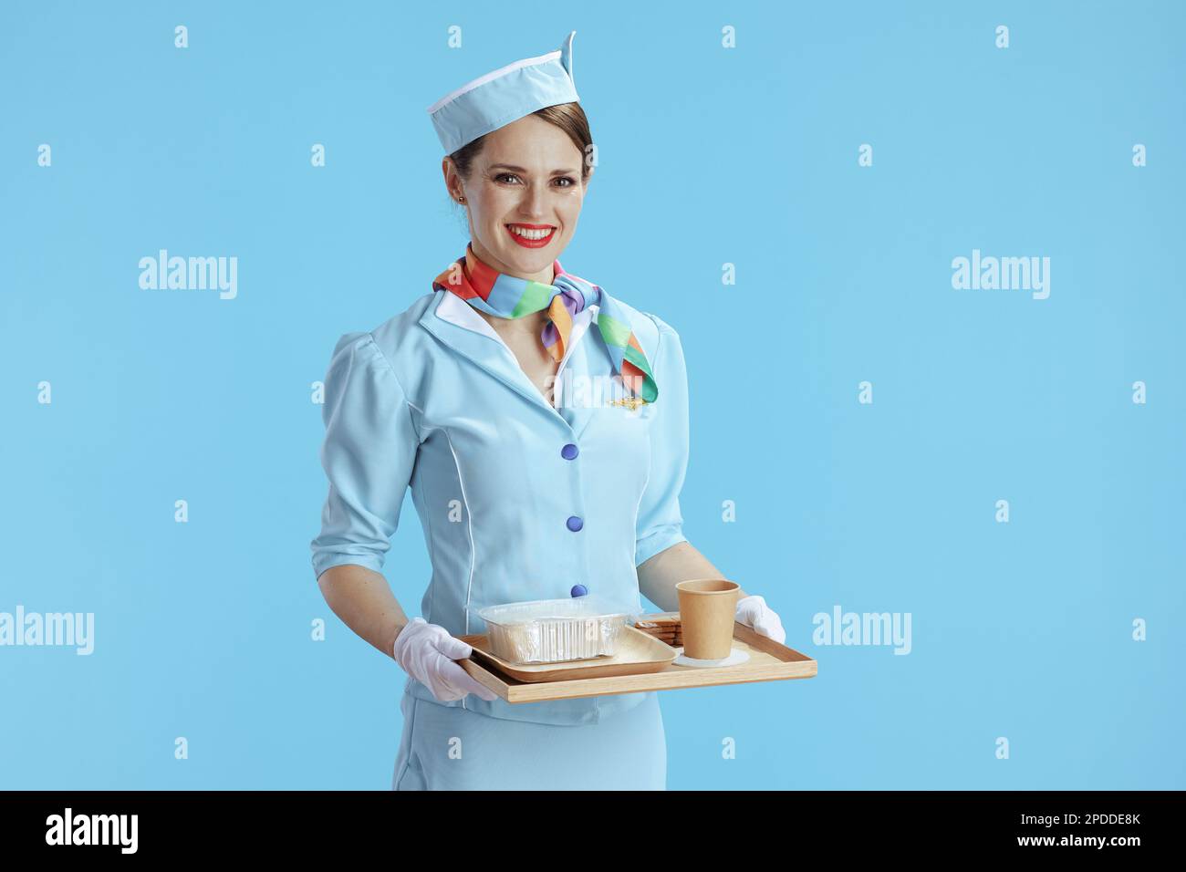 smiling modern air hostess woman against blue background in blue ...