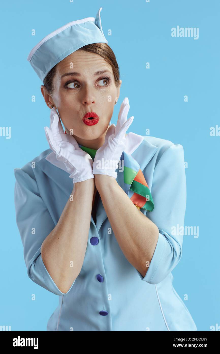 surprised modern flight attendant woman isolated on blue background in ...