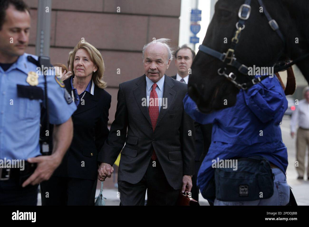 Enron founder Ken Lay and his wife Linda walk across a street in ...