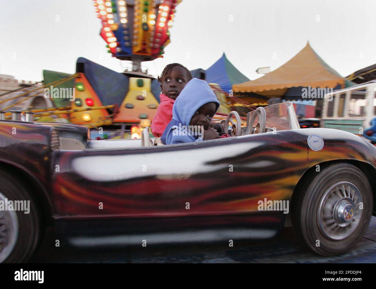 Two children ride in a small car at a games park, Magic Land at Dakar ...