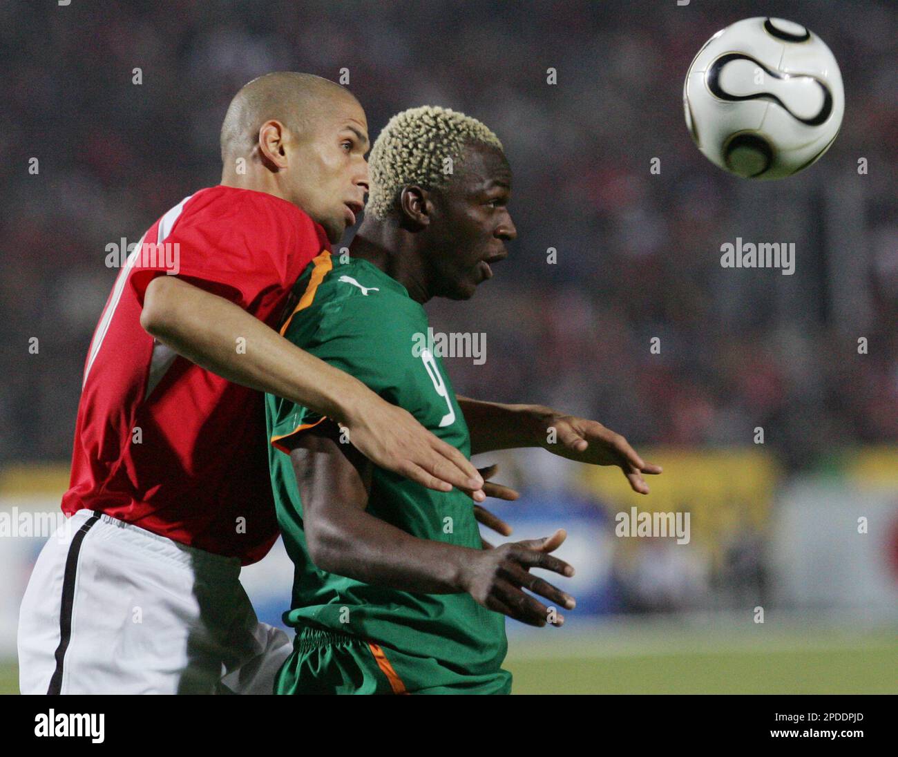 Ivory Coast's Kone Arouna, right, eyes the ball with Egypt's Wael Gomaa ...