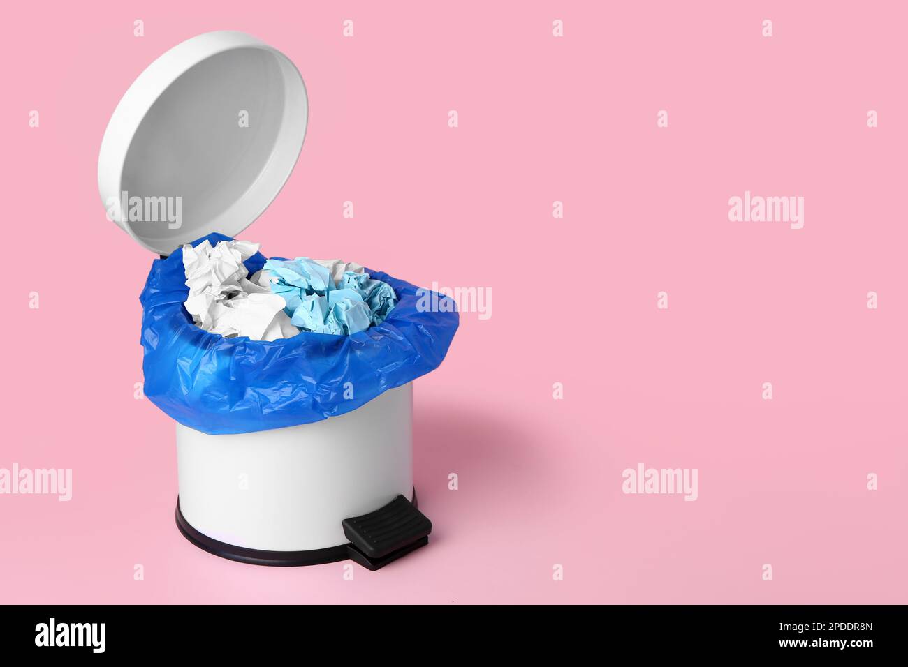 Open rubbish bin with crumpled paper on pink background Stock Photo - Alamy