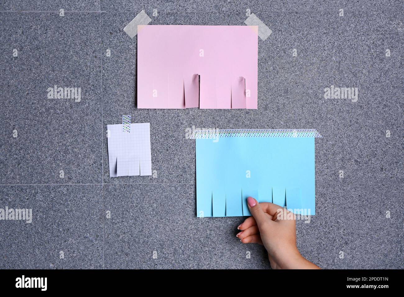 Woman tearing off paper ad from granite wall Stock Photo - Alamy