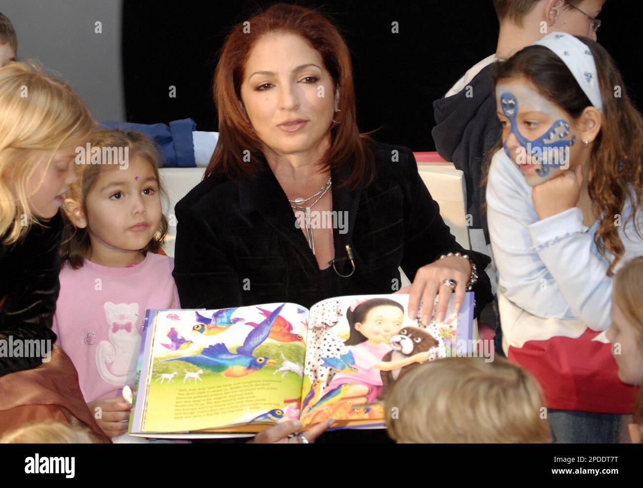 Singer Gloria Estefan looks up to her audience while reading her book ...