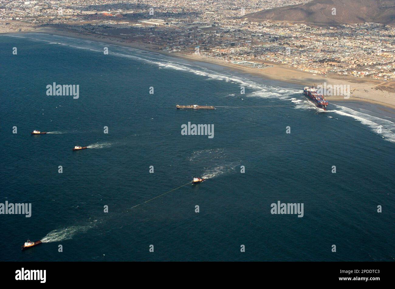 Tugboats work in tandem with powerful winches mounted on a barge to ...