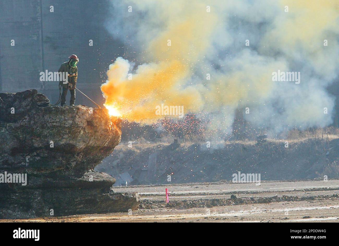 A worker from North Atlantic Dismantling uses a large torch to cut ...