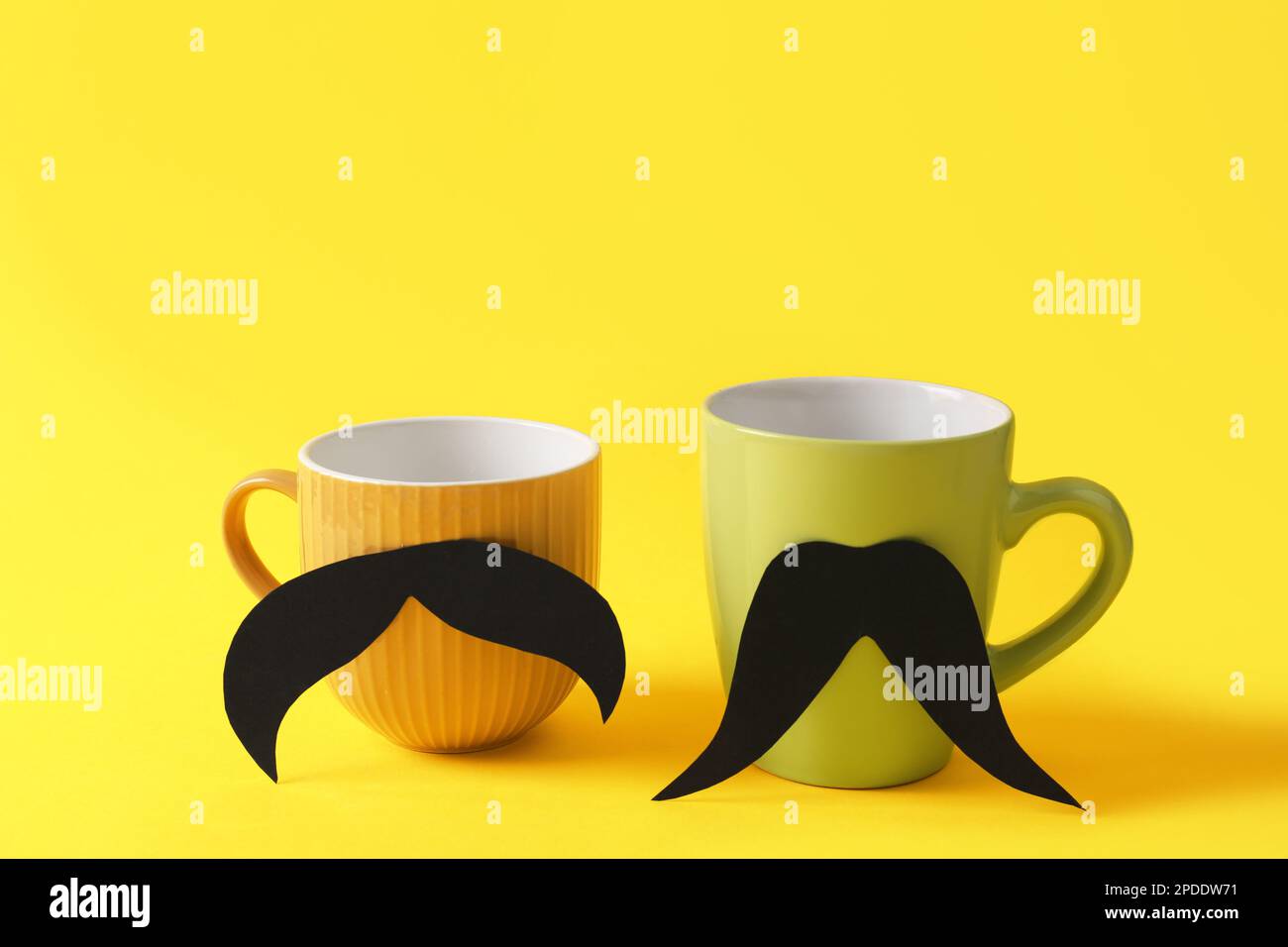 Cups with paper mustaches on yellow background Stock Photo - Alamy