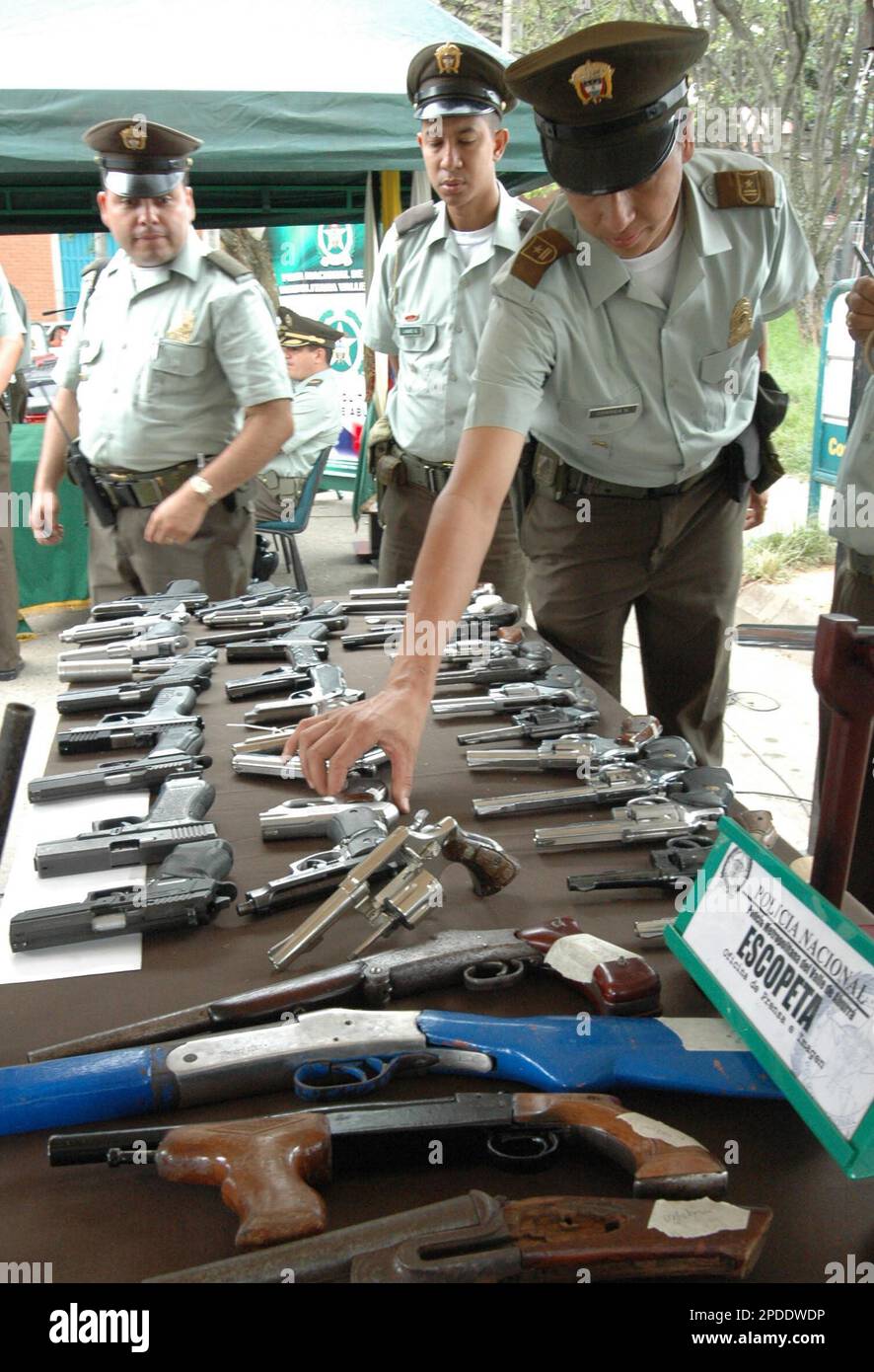 Three officials of the Colombian national police inspect a display of ...