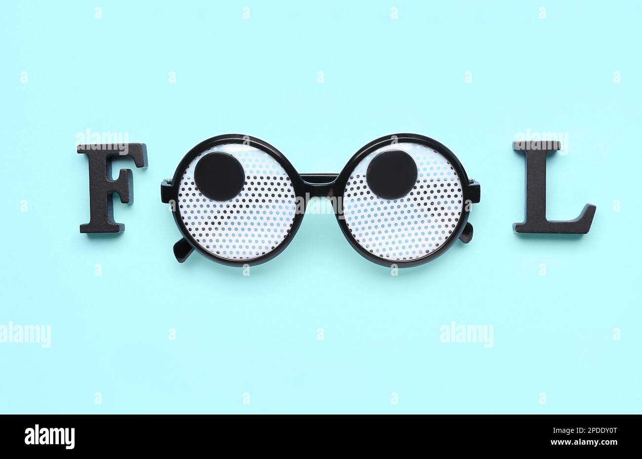 Word FOOL with funny eyeglasses on blue background Stock Photo - Alamy