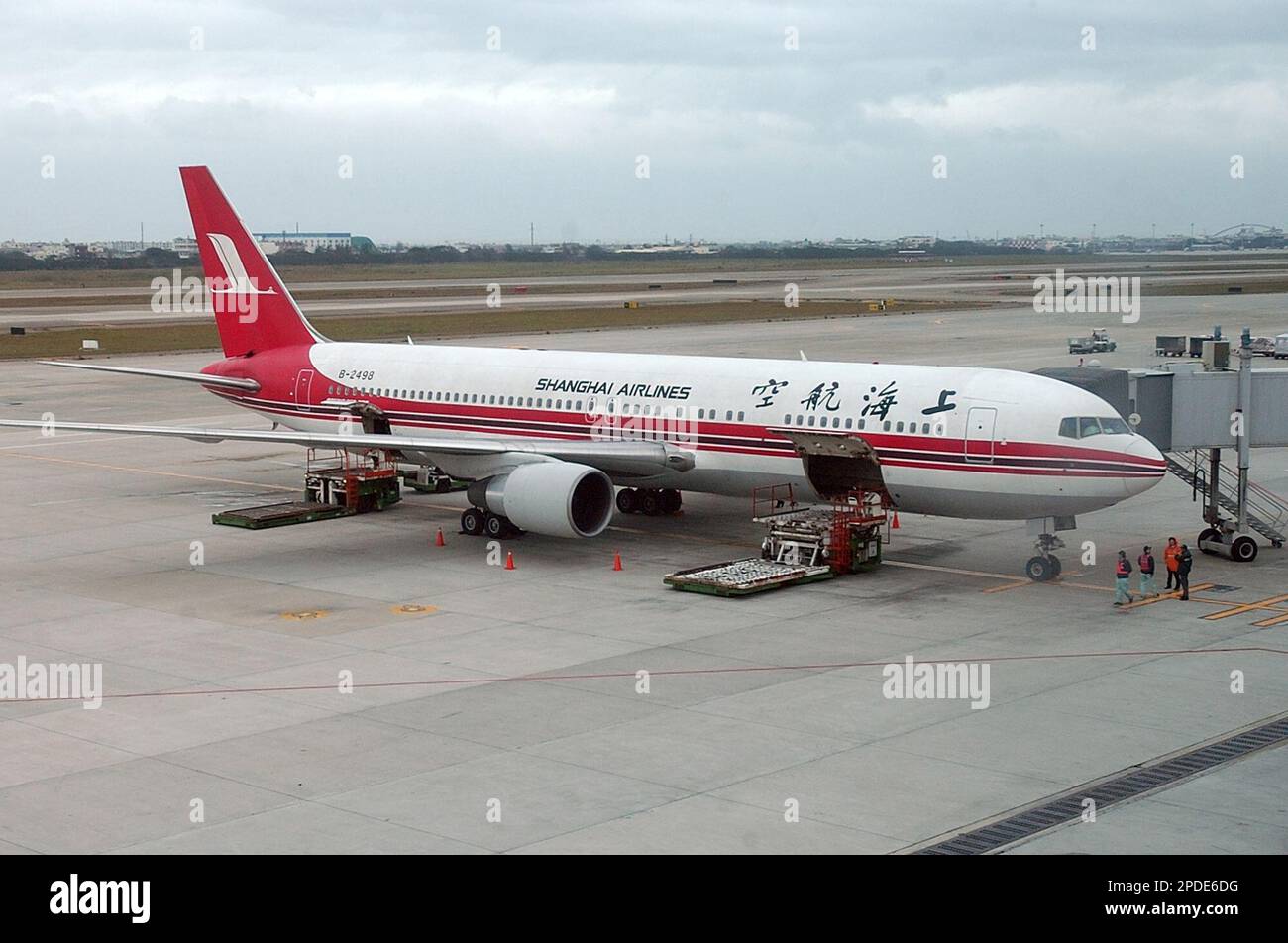 Taiwanese ground crew attend to a Chinese Shanghai Airlines plane on ...