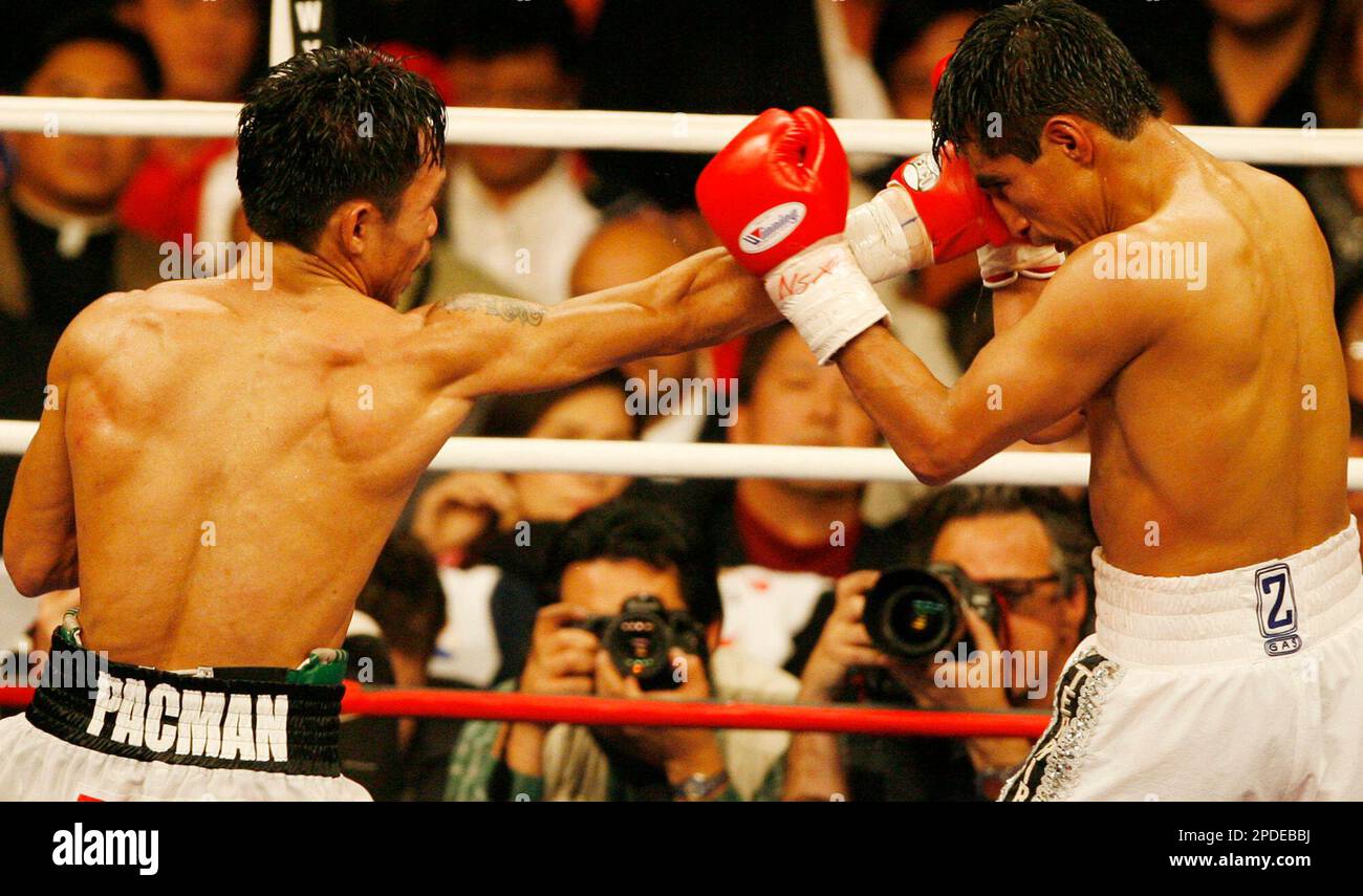 Erik Morales, right, of Mexico, takes a punch from Manny Pacquiao, of the Philippines, during ...