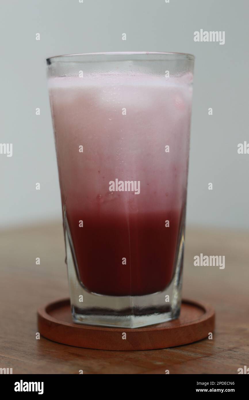 a glass of red velvet latte served cold on the table Stock Photo - Alamy