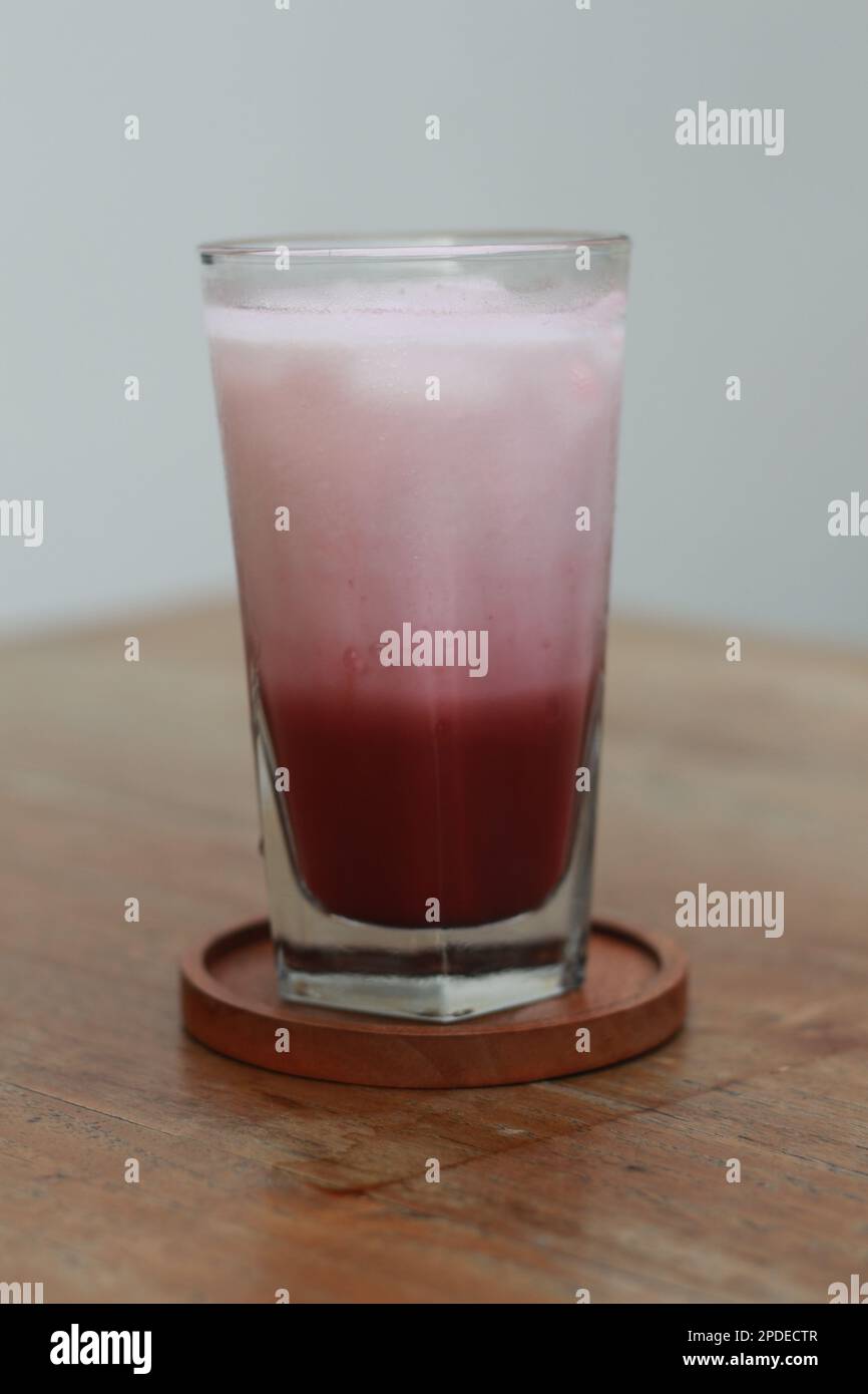 a glass of red velvet latte served cold on the table Stock Photo - Alamy