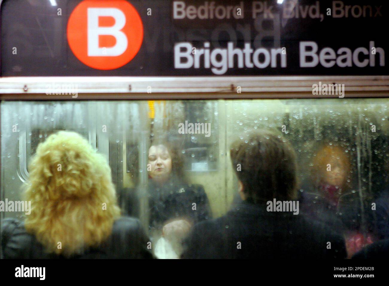 Morning commuters are seen through a rain soaked and fogged uptown ...