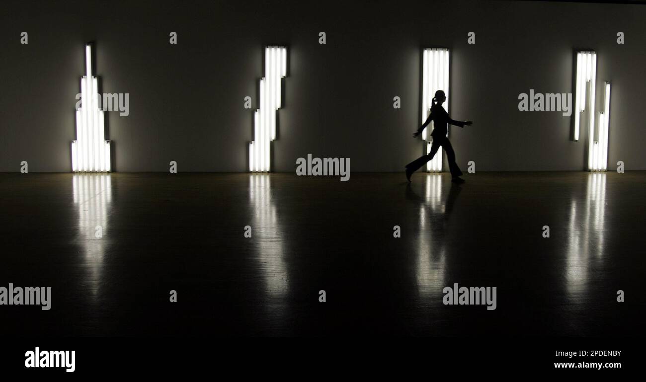 A gallery visitor walks past a light work by American artist Dan Flavin ...