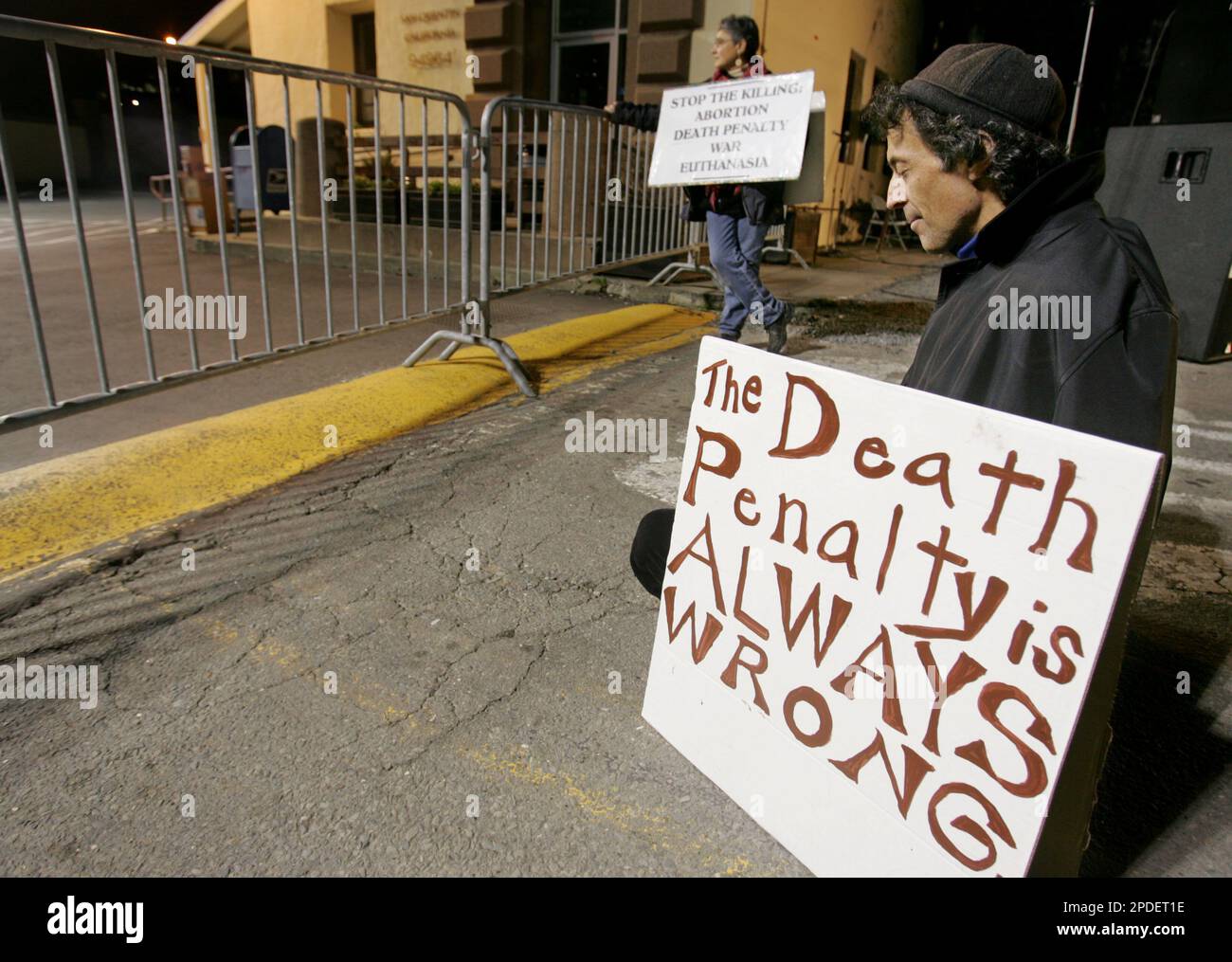 Death penalty opponent William Rogers prays near the front gate of San ...