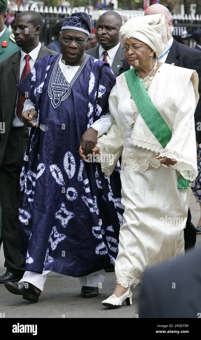 Liberia's President Ellen Johnson Sirleaf, right, walks hand in hand ...