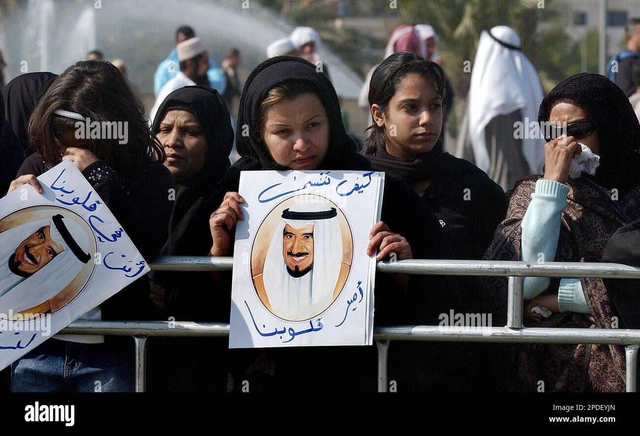 Kuwaiti women weep and hold posters of the emir of Kuwait, Sheik Jaber ...
