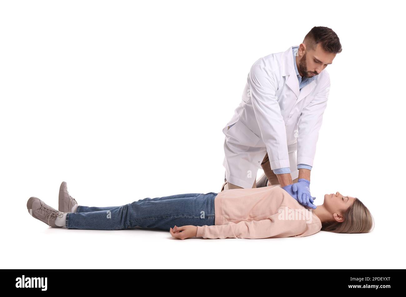 Doctor in uniform performing first aid on unconscious woman against ...
