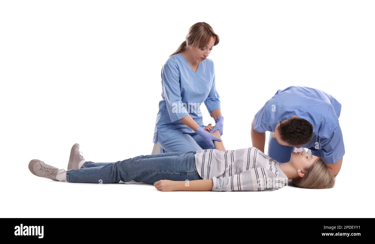 Medical workers in uniform performing first aid on unconscious woman ...