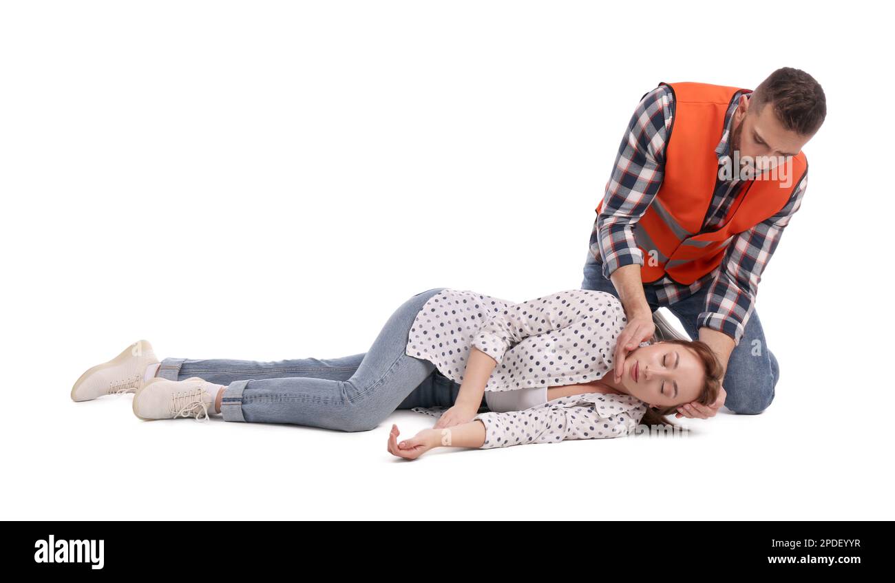 Paramedic in uniform performing first aid on unconscious woman against ...