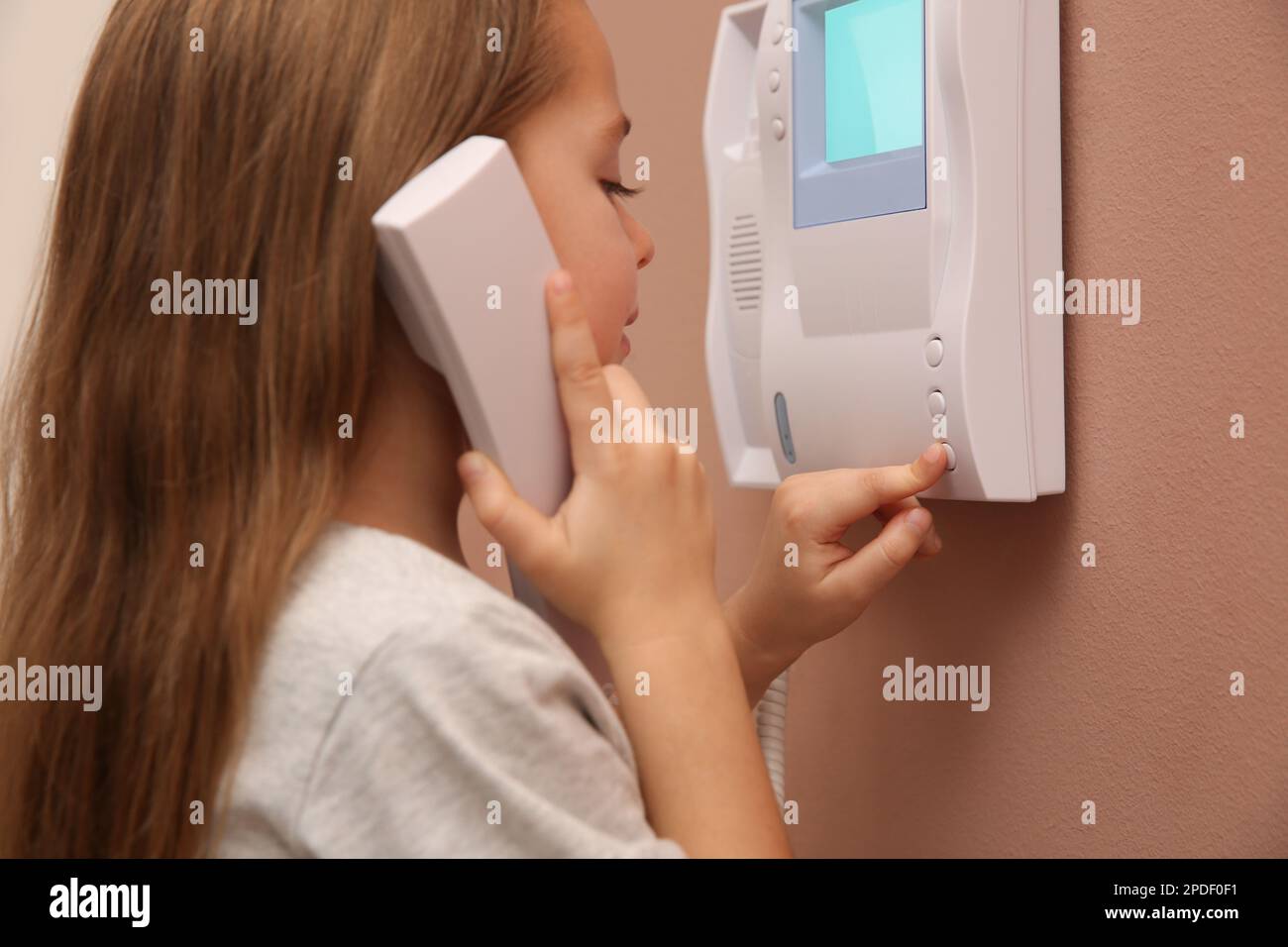 Cute little girl answering intercom call indoors, closeup Stock Photo ...