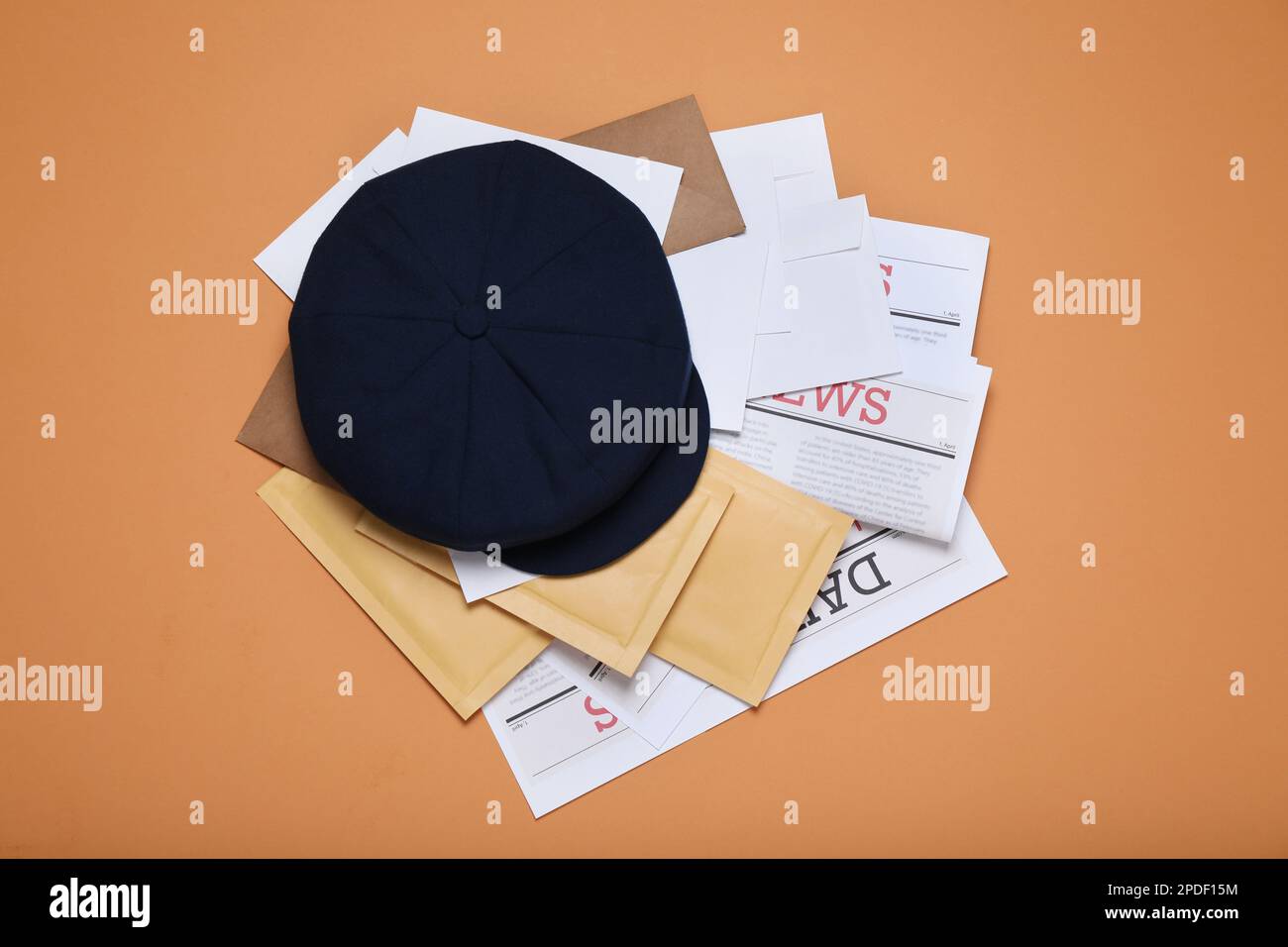 Postman hat, newspapers and mails on light brown background, flat lay ...