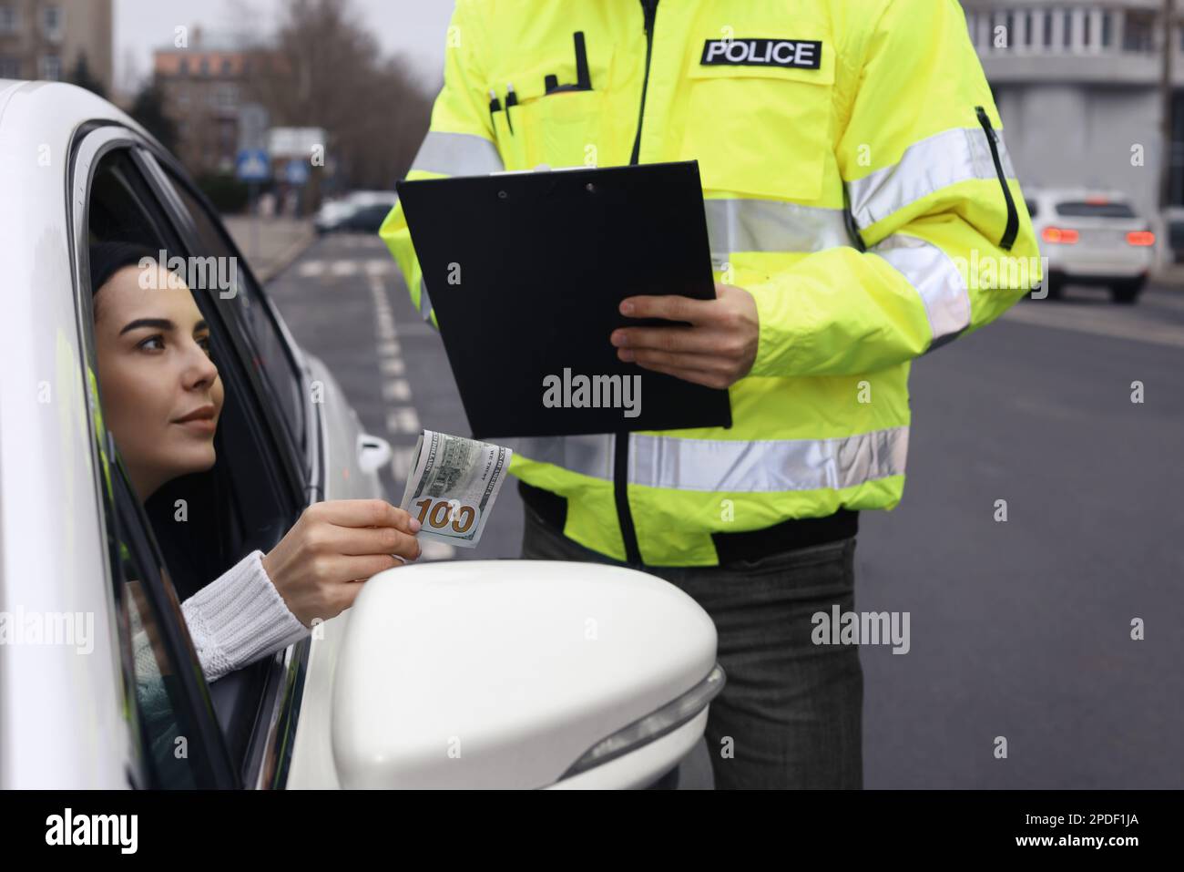 Woman giving bribe to police officer out of car window Stock Photo - Alamy