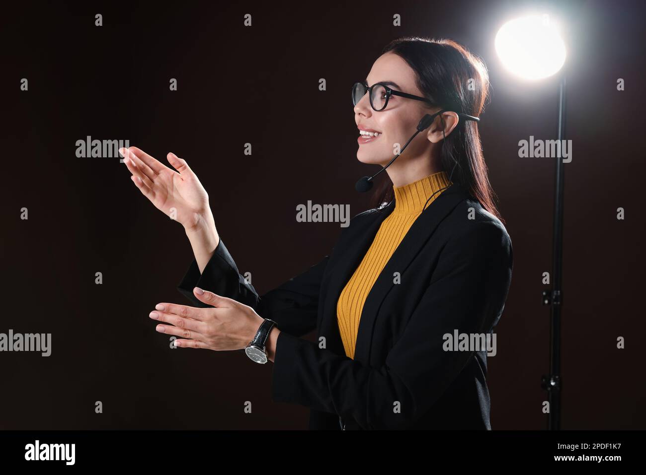 Motivational speaker with headset performing on stage Stock Photo - Alamy
