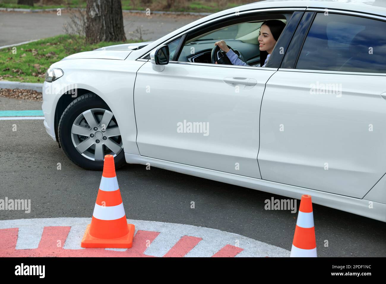 Young woman in car on test track with traffic cones. Driving school ...