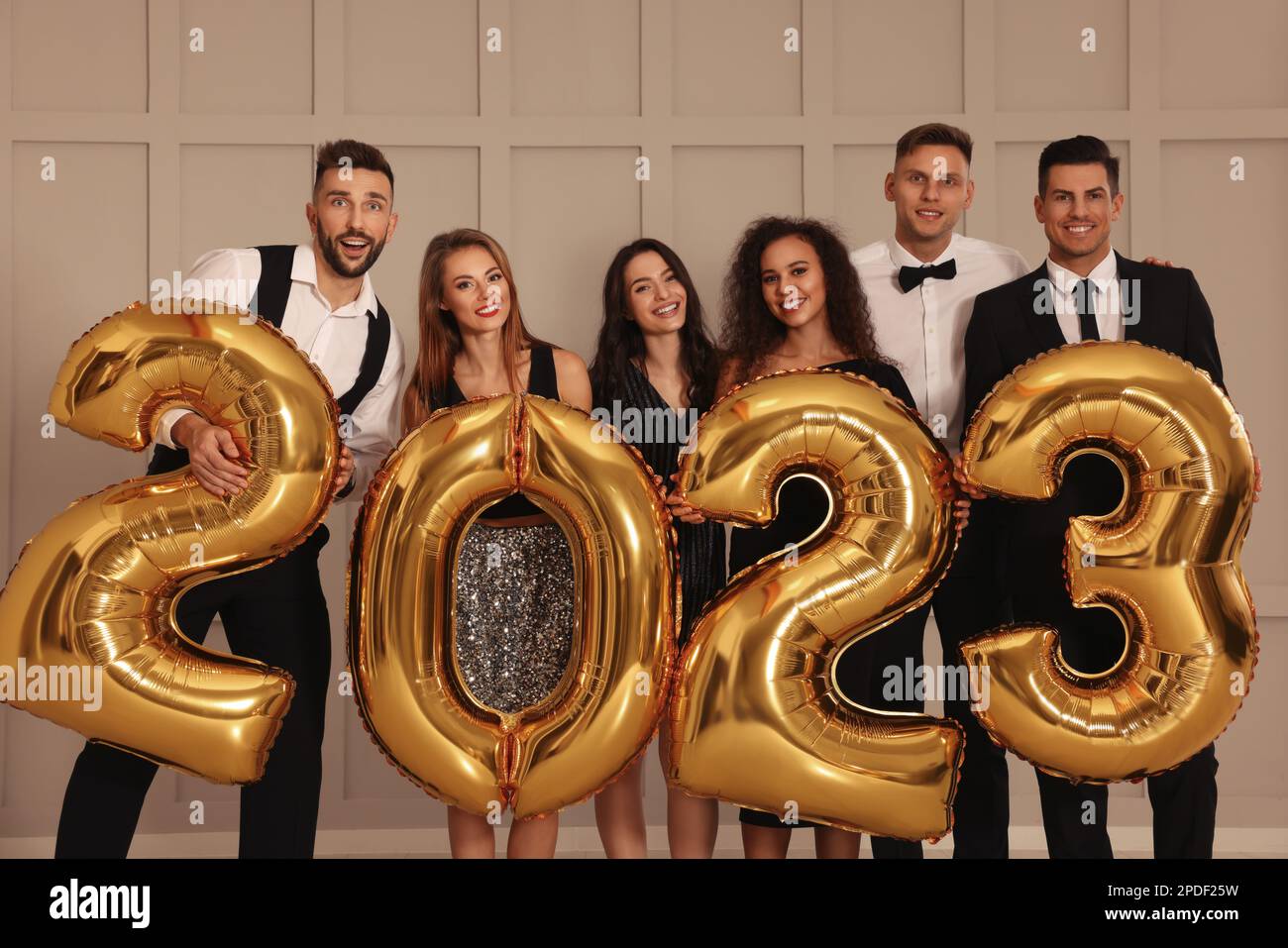 Happy friends with golden 2023 balloons indoors. New Year celebration ...