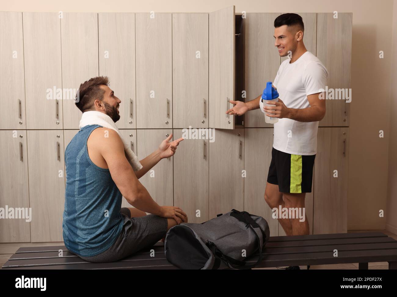 Handsome athletic men talking in locker room Stock Photo - Alamy