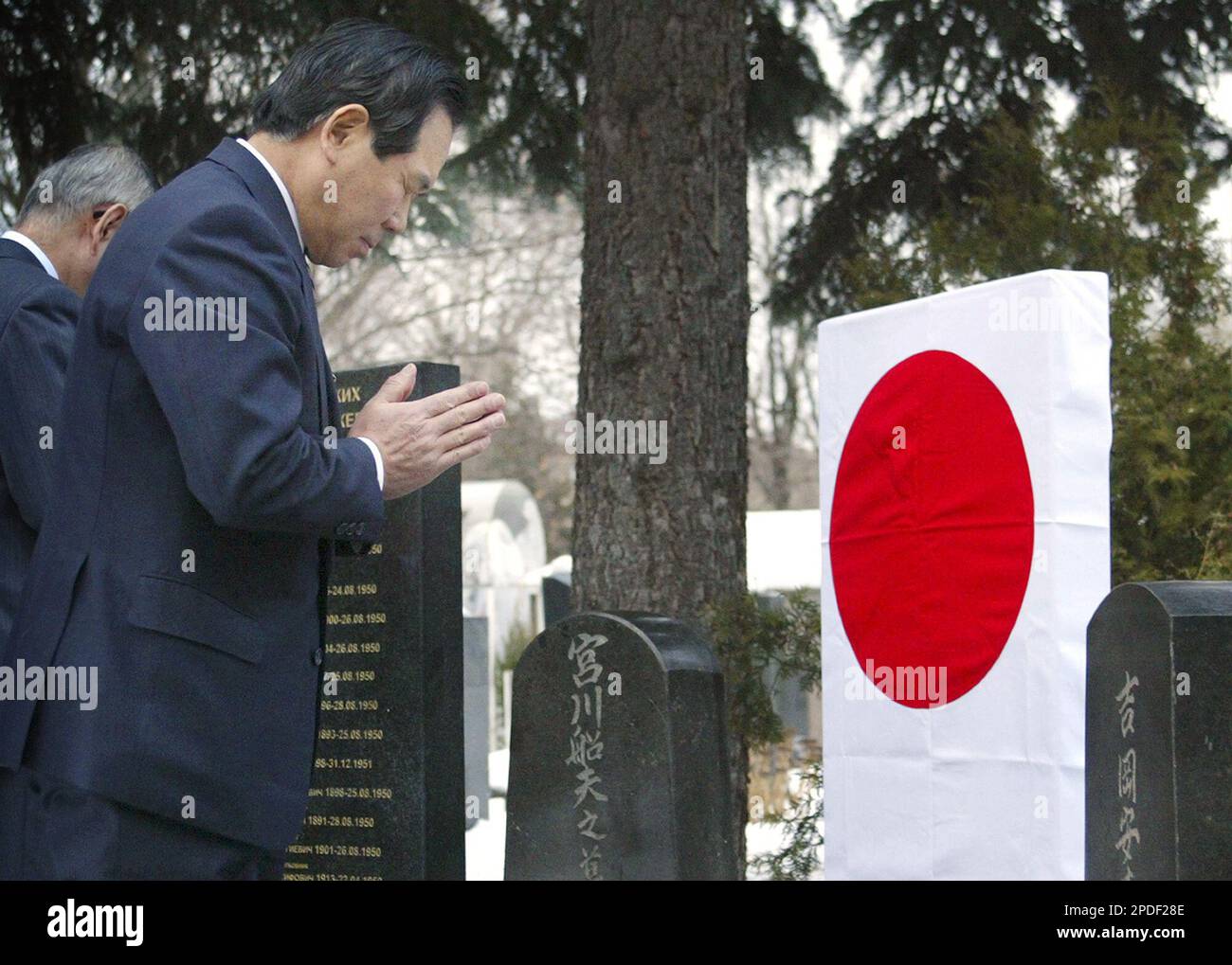 Japanese Defense Agency chief Fukushiro Nukaga, left, prays in front of ...
