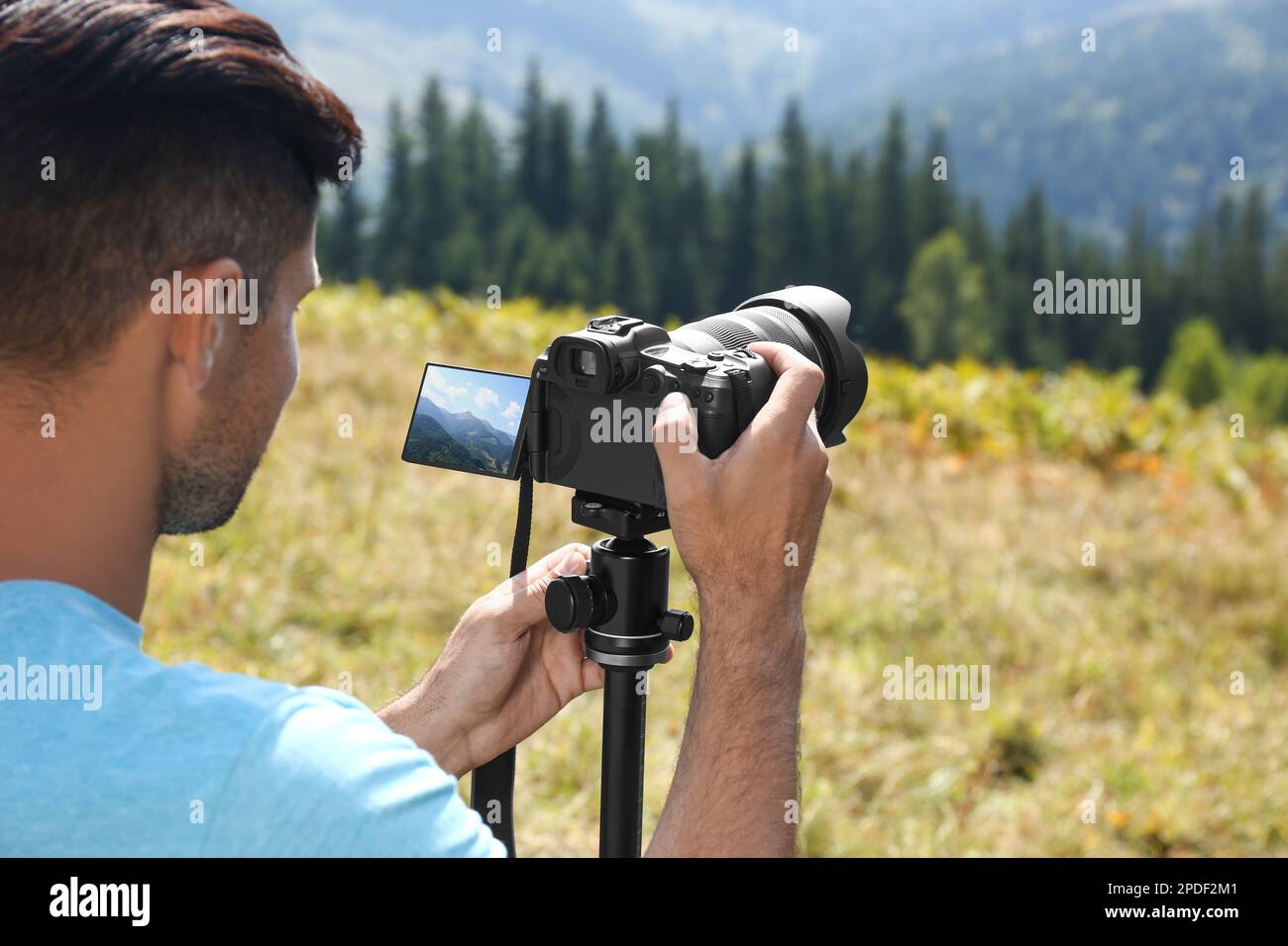 Man taking photo of nature with modern camera on stand outdoors Stock ...