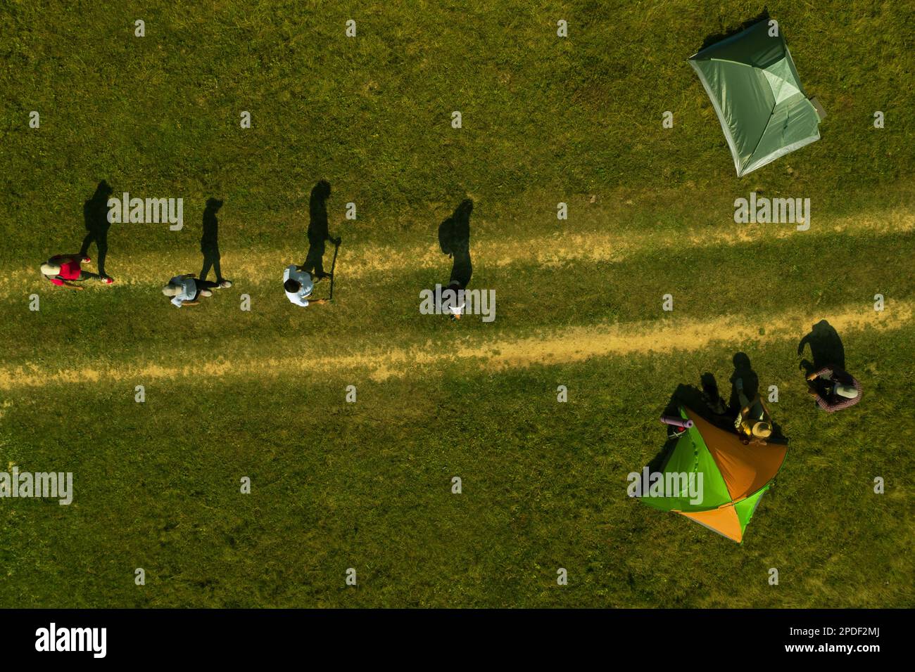 Group of tourists near tents in campsite, top aerial view. Drone ...