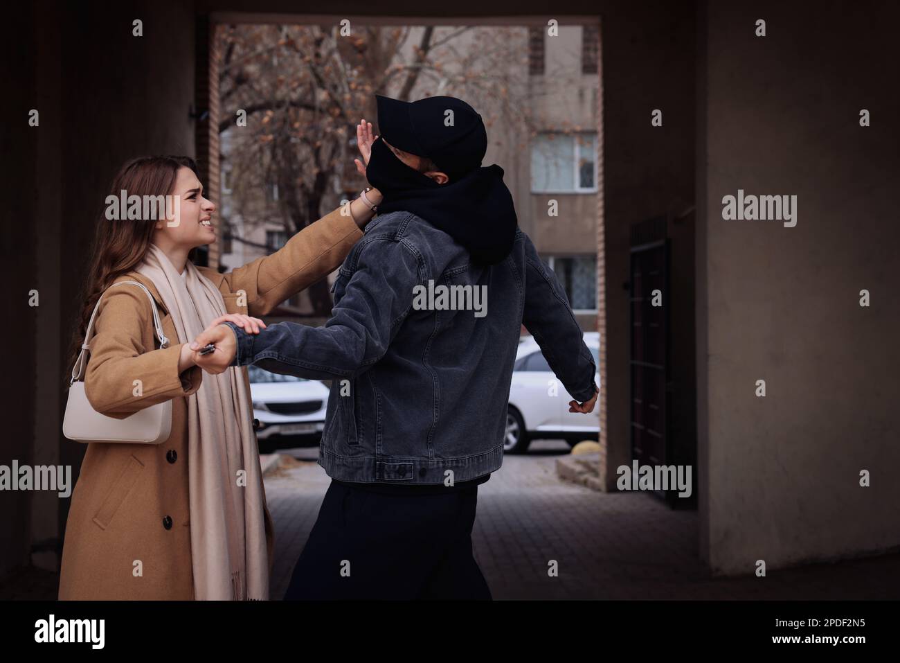 Woman defending herself from attacker with knife in alley Stock Photo ...