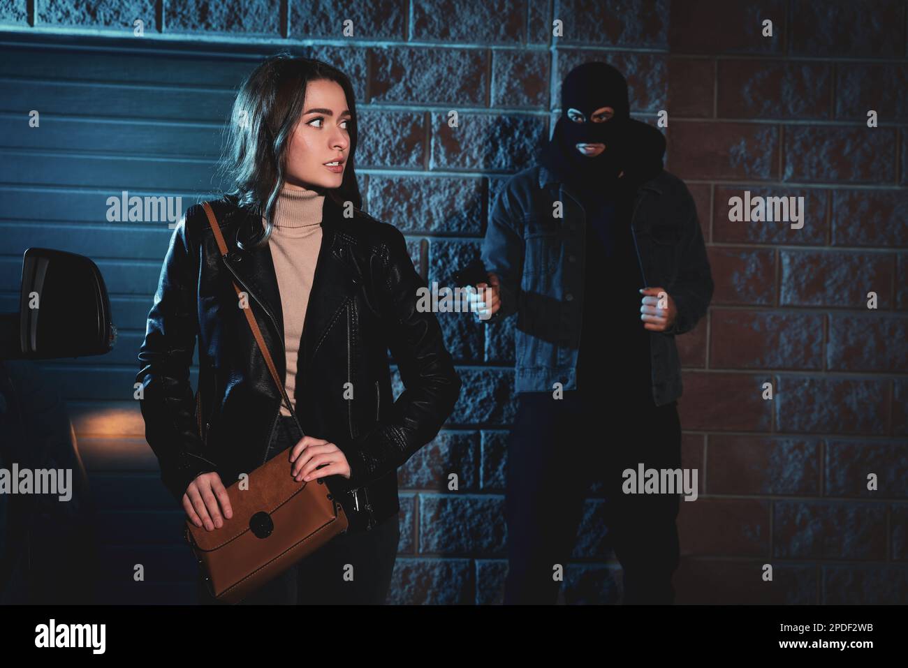 Criminal threatening young woman with gun outdoors at night. Self ...