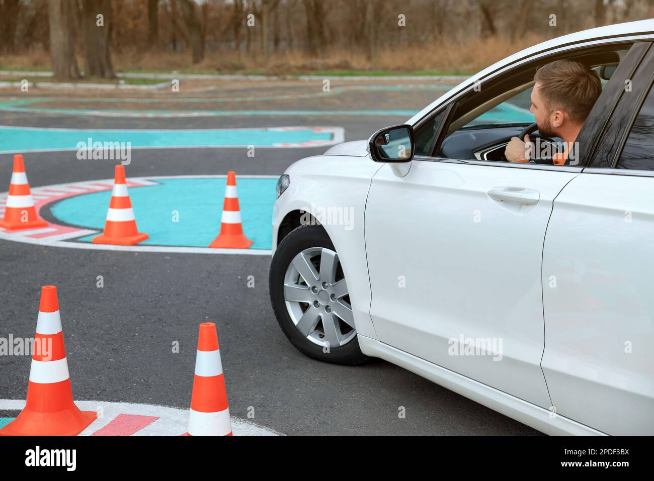 Young man in car on test track with traffic cones. Driving school Stock ...