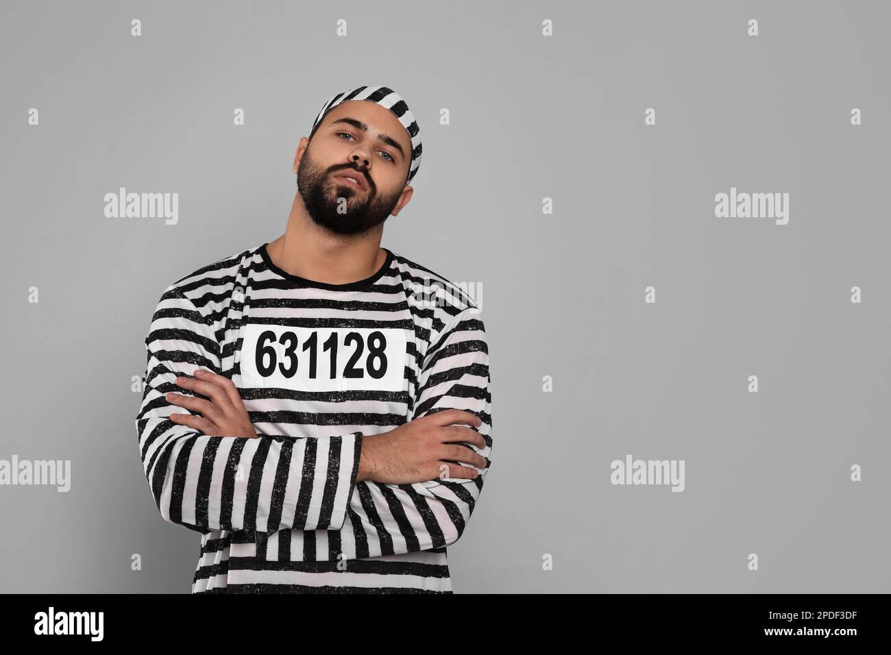 Prisoner in special uniform on grey background, space for text Stock ...