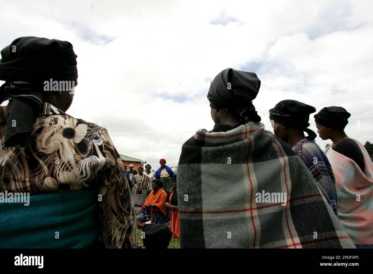 A group of Xhosa women dressed in black scarfs and blankets, mourn the ...